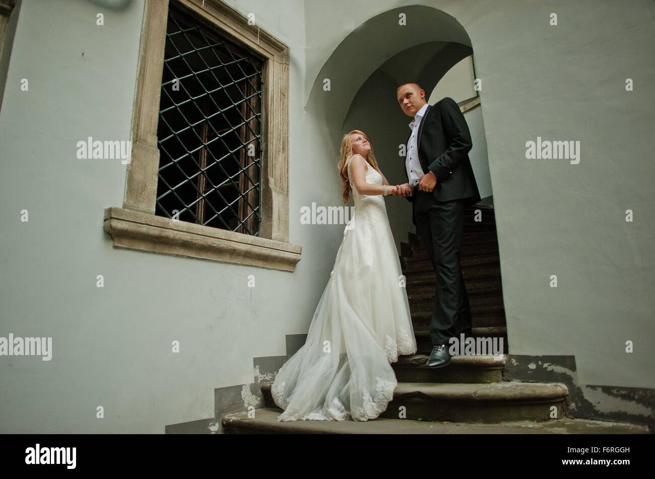 Wedding couple under stone arch Stock Photo - Alamy