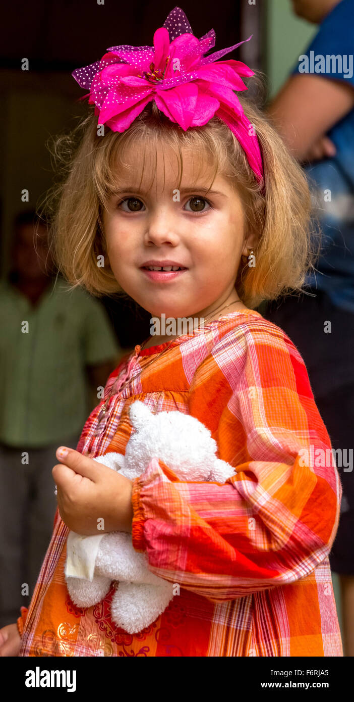 little Cuban girl with a white teddy bear and pink ribbon in her hair ...