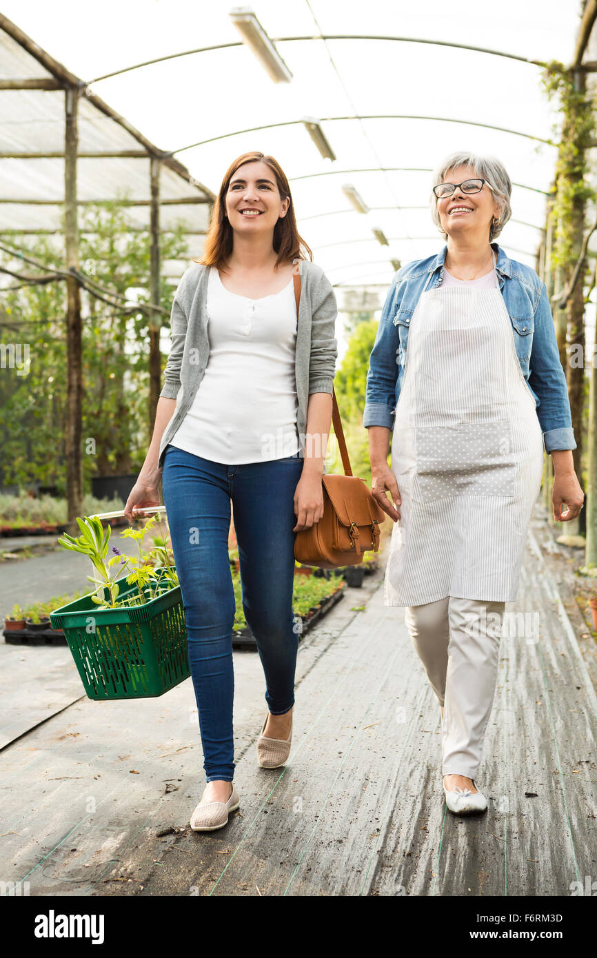 Florist and customer walking together in a greenhouse Stock Photo - Alamy