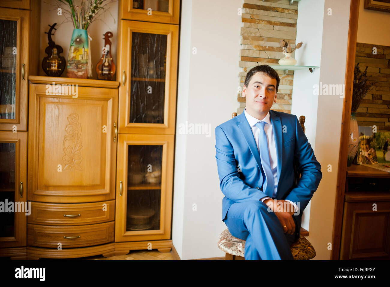 groom gets dressed in formal wear and blue suit Stock Photo - Alamy