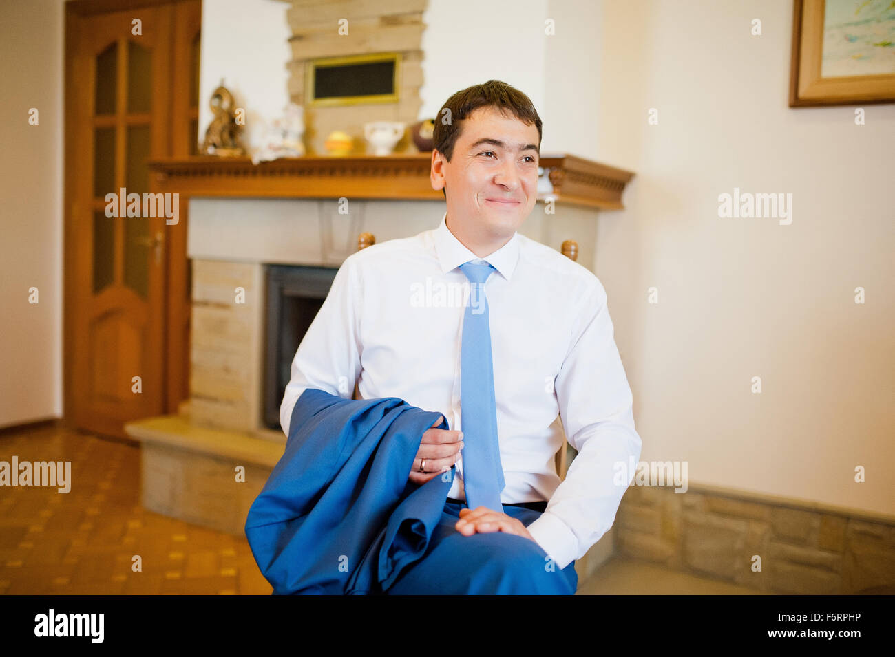 groom gets dressed in formal wear and blue suit Stock Photo - Alamy