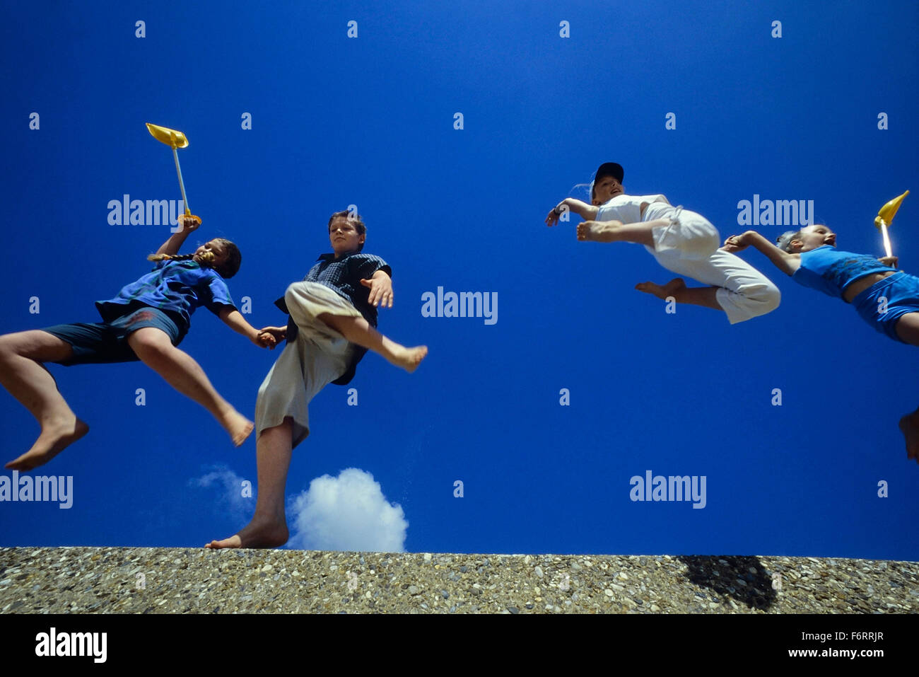 Youngsters jumping off a wall. Great Yarmouth. Norfolk. UK Stock Photo ...