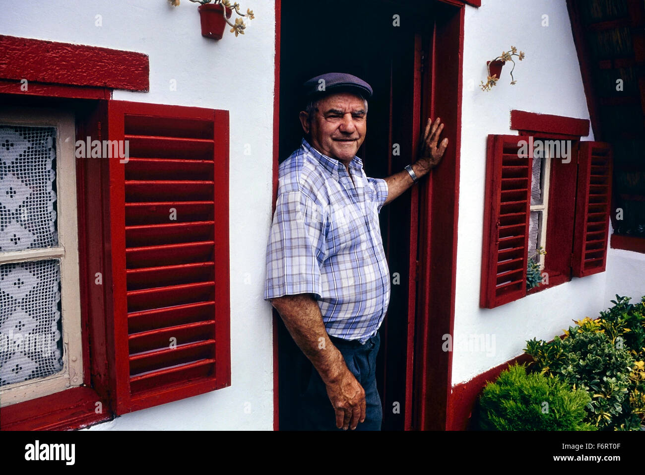 A local man in the doorway of his Traditional A-framed Palheiro home ...