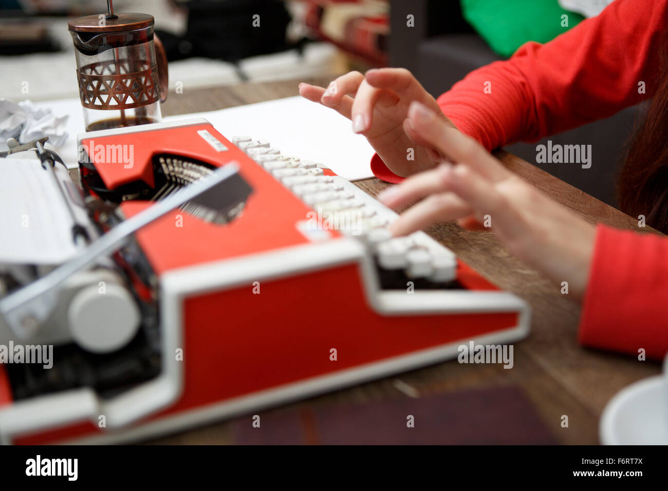 woman at table typing on old red typewriter Stock Photo - Alamy