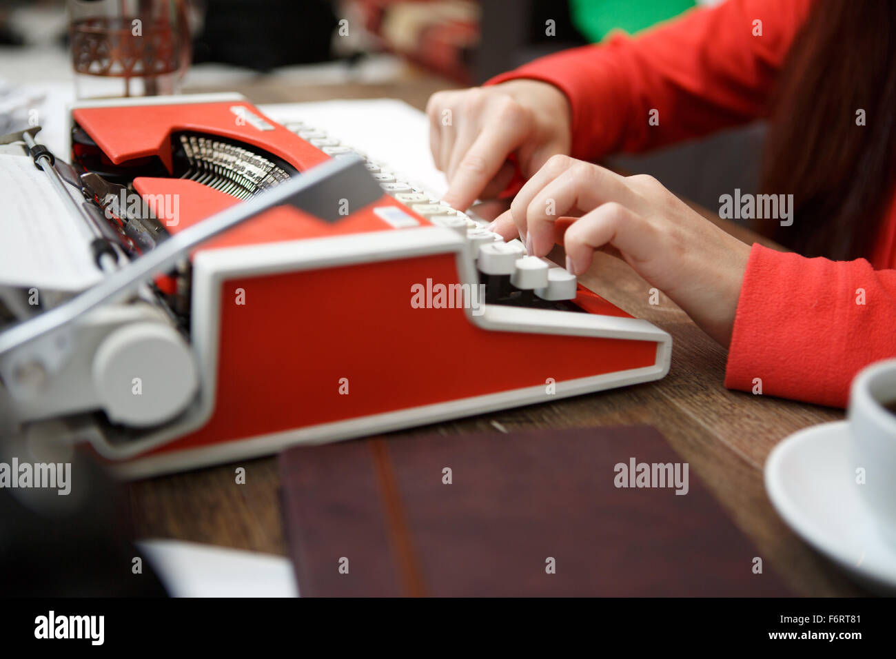 woman at table typing on typewriter Stock Photo - Alamy