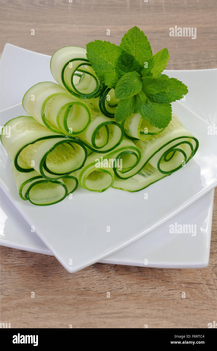 Salad cucumber ribbons twisted in rolls with mint Stock Photo - Alamy