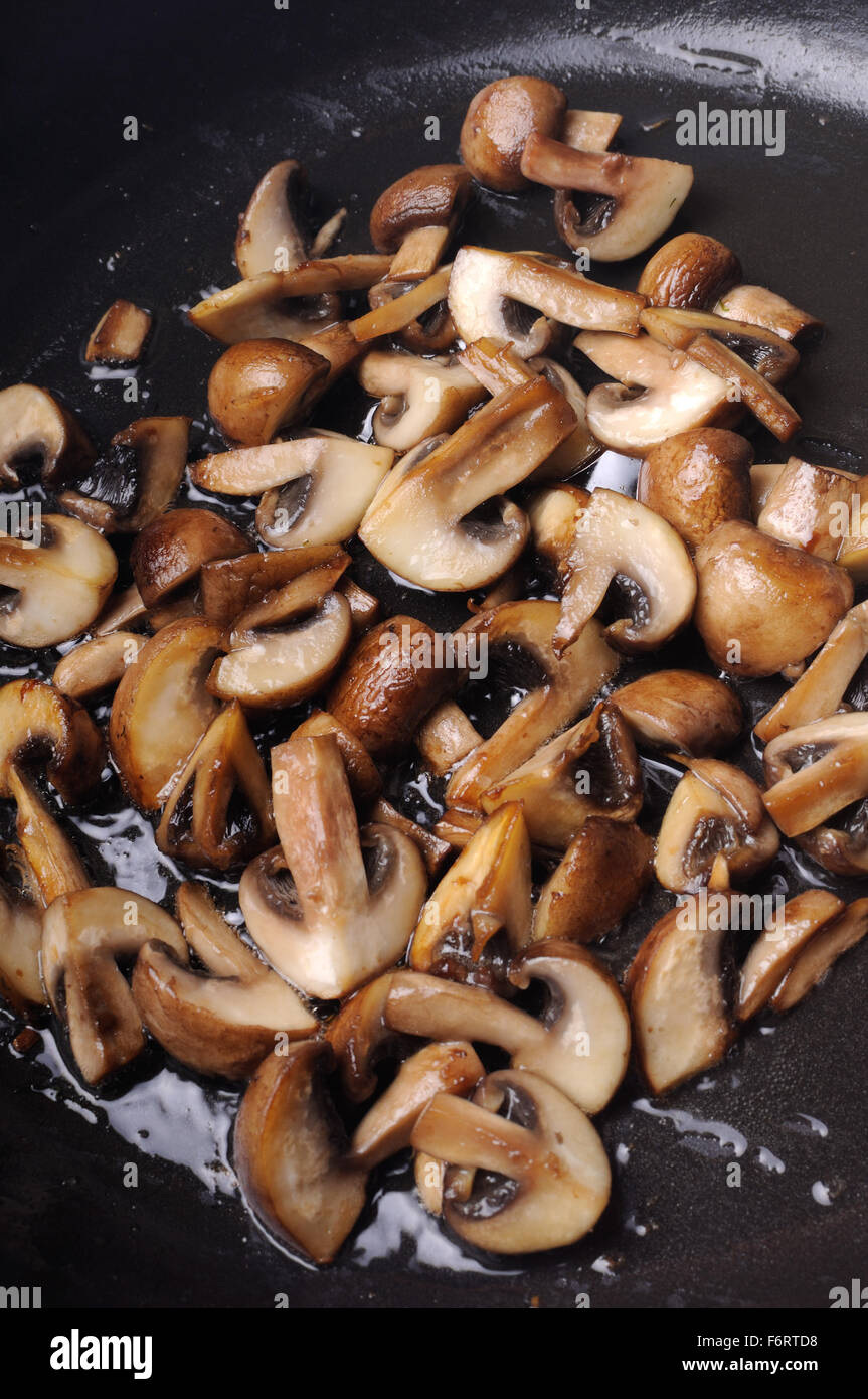 Fried sliced mushrooms in butter in a frying pan. For step by step ...