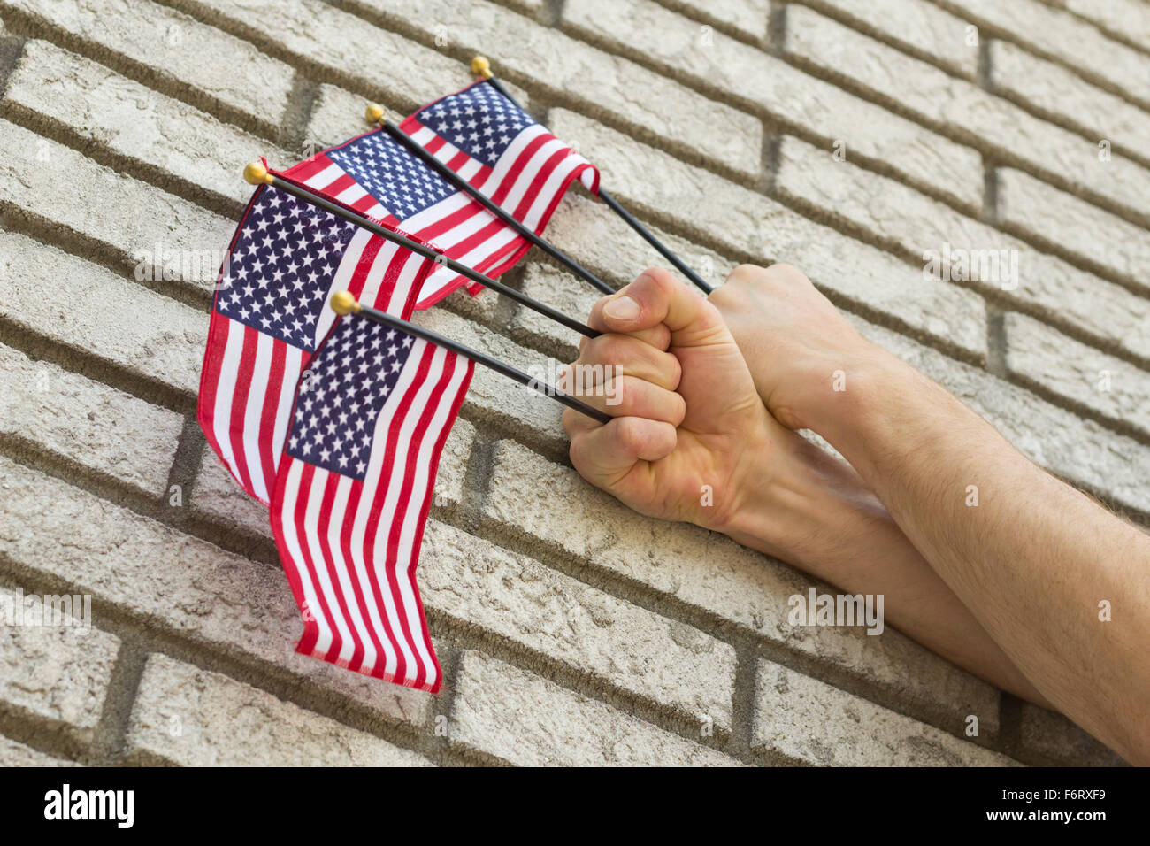 Fists clench small American flags in patriotic imagery Stock Photo - Alamy