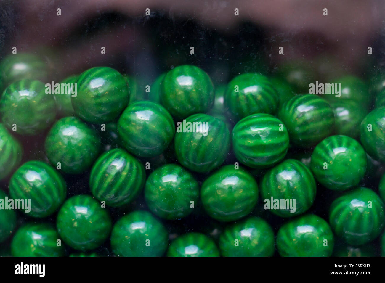 Close up of green candy gum balls in candy machine Stock Photo - Alamy