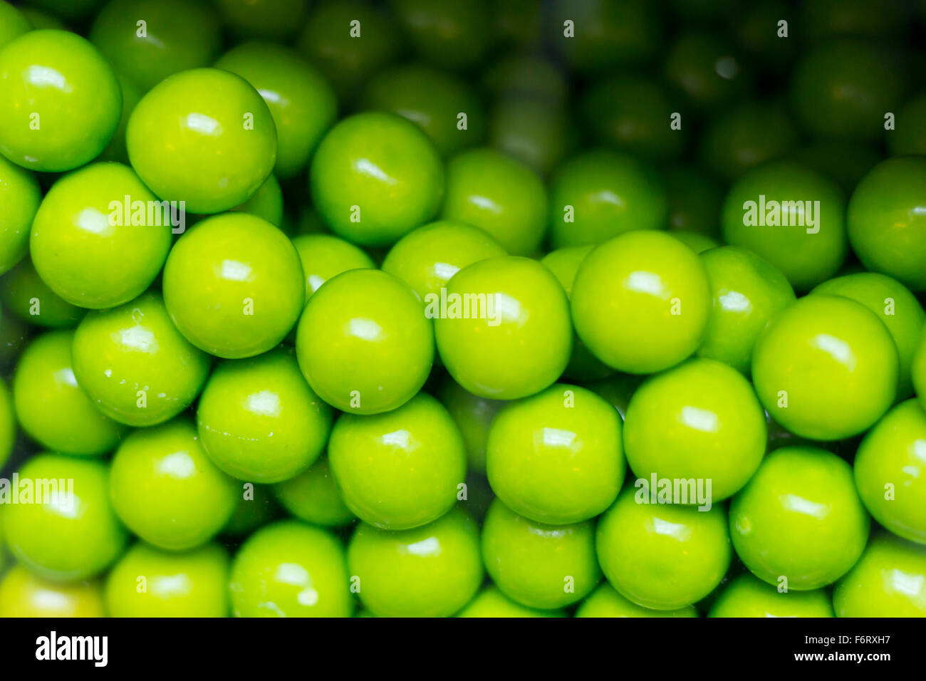 Close up of green candy gum balls in candy machine Stock Photo - Alamy