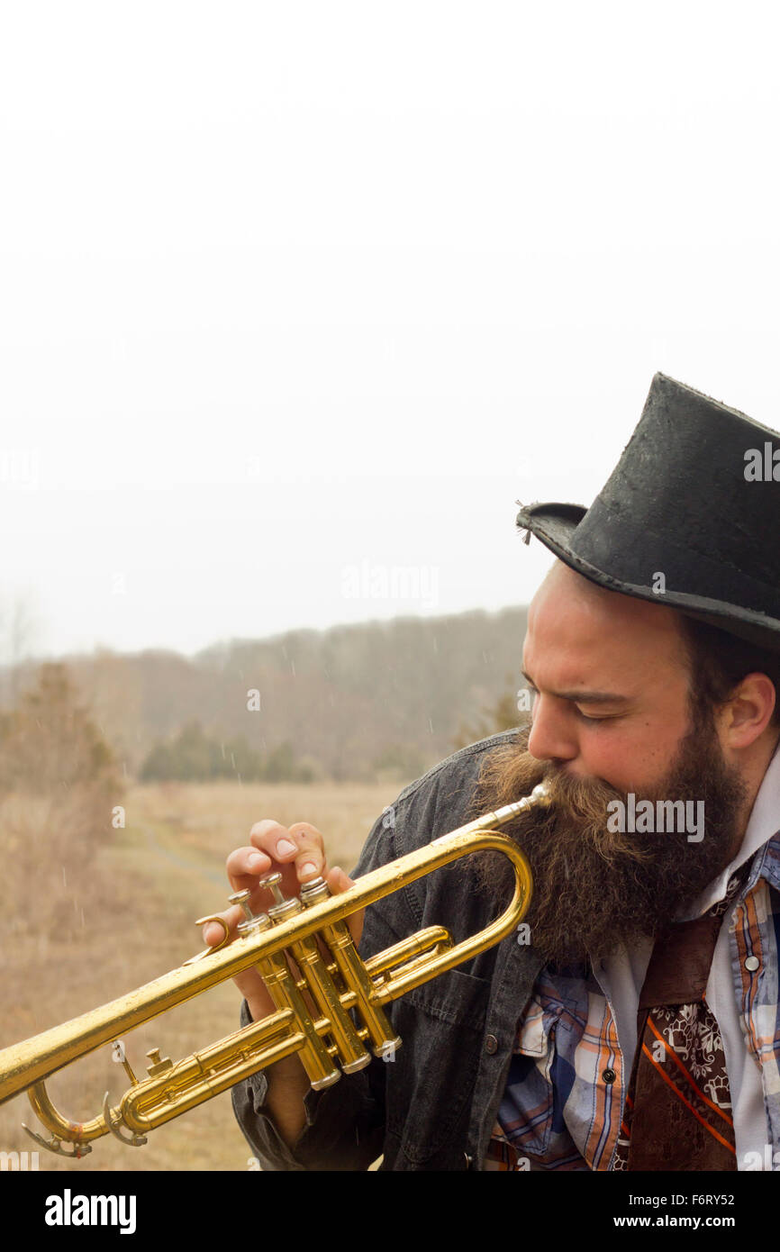 Stylish bearded gypsy plays trumpet on a wilderness path Stock Photo ...