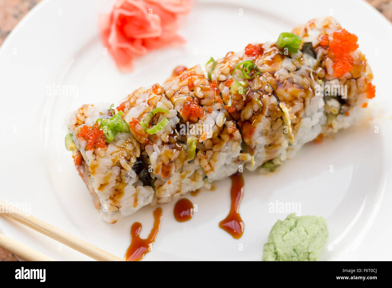 Fancy Philadelphia sushi roll topped with roe sushi sauce and chopped ...