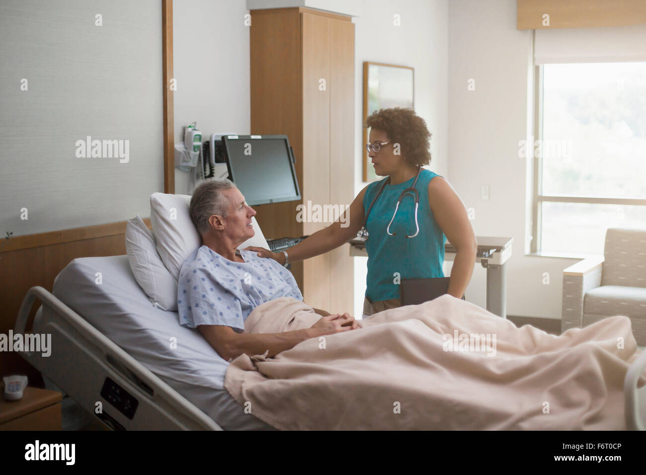 Doctor talking to patient in hospital room Stock Photo - Alamy