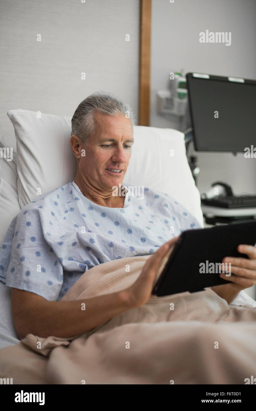 Caucasian man using digital tablet in hospital room Stock Photo - Alamy