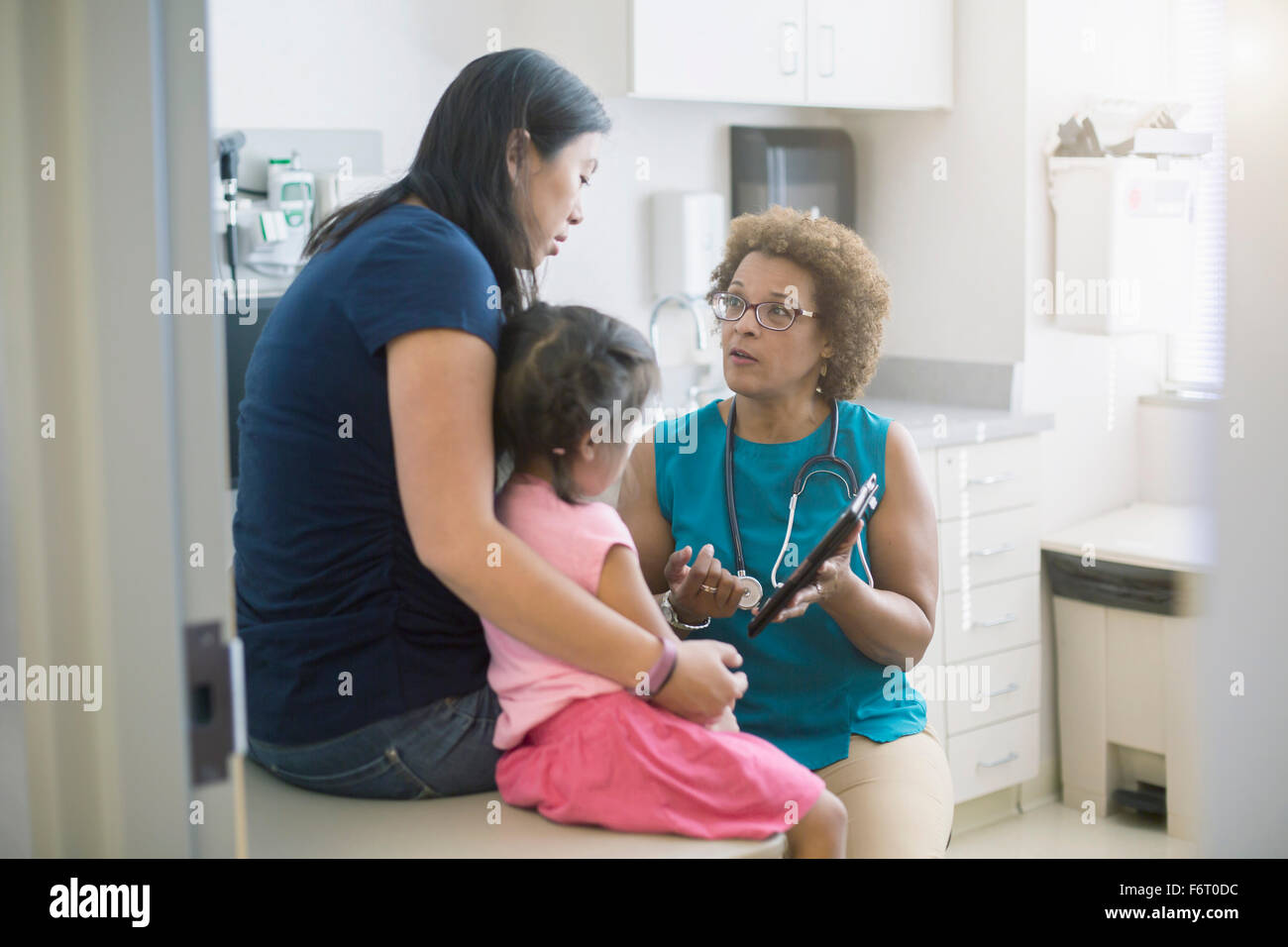 Doctor using digital tablet with patients Stock Photo - Alamy