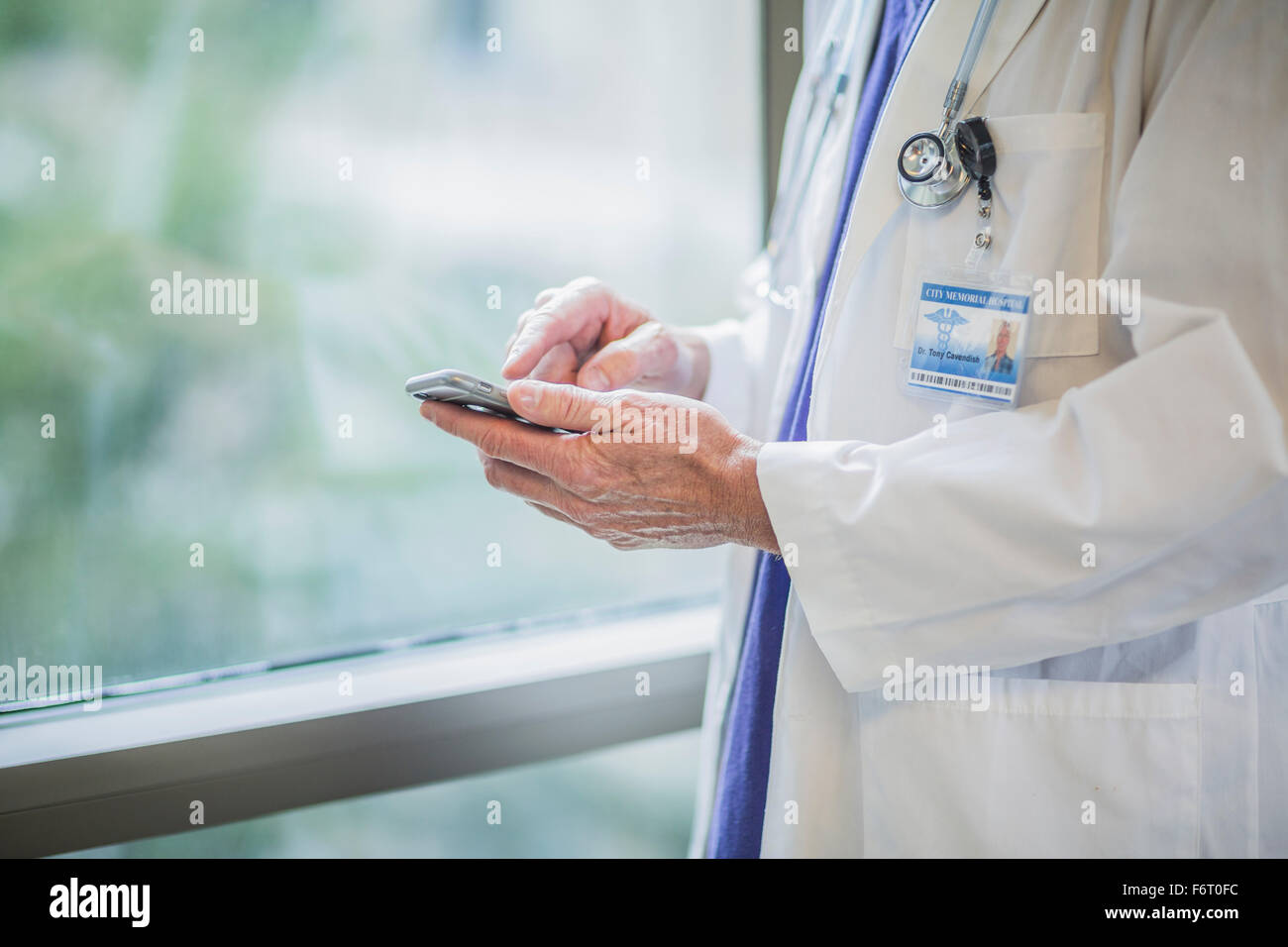 Caucasian doctor using cell phone Stock Photo - Alamy