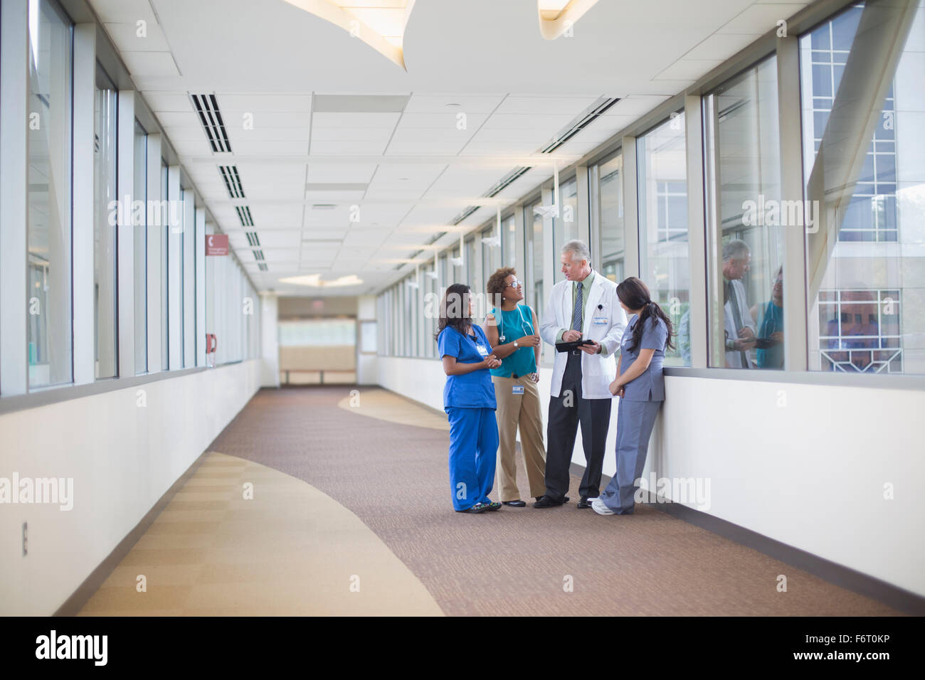 Doctor and nurses talking in hospital hallway Stock Photo - Alamy
