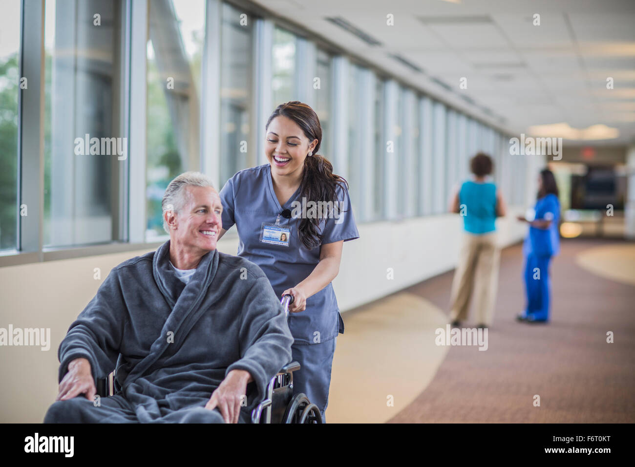 Nurse pushing patient in wheelchair Stock Photo - Alamy
