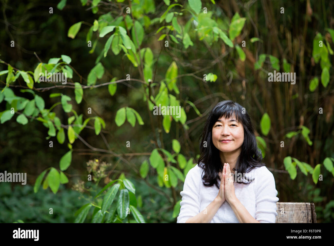 Japanese woman meditating in garden Stock Photo - Alamy