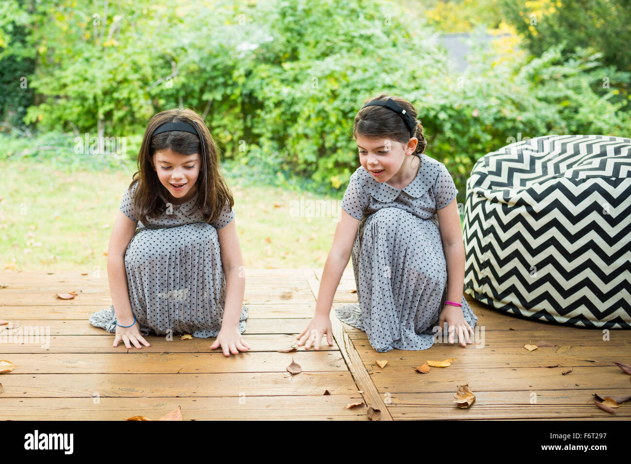 Twin sisters playing on deck Stock Photo - Alamy