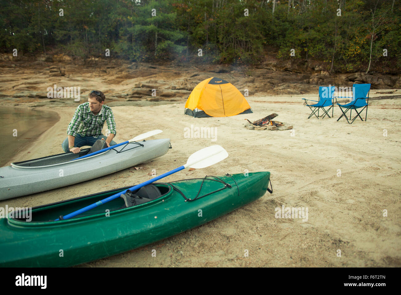 Man pushing kayak into lake Stock Photo - Alamy