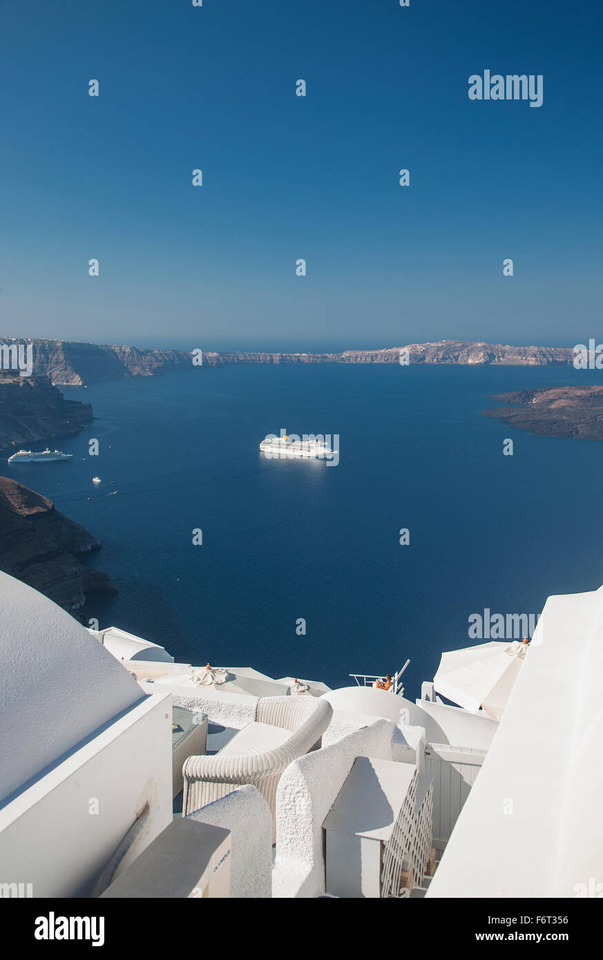 Hillside buildings over cruise ship in Santorini bay, Cyclades, Greece ...