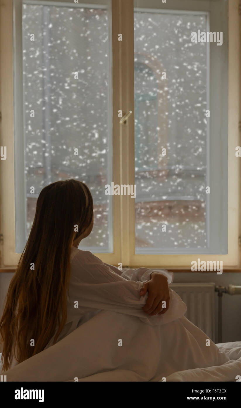 Caucasian woman looking out window Stock Photo - Alamy