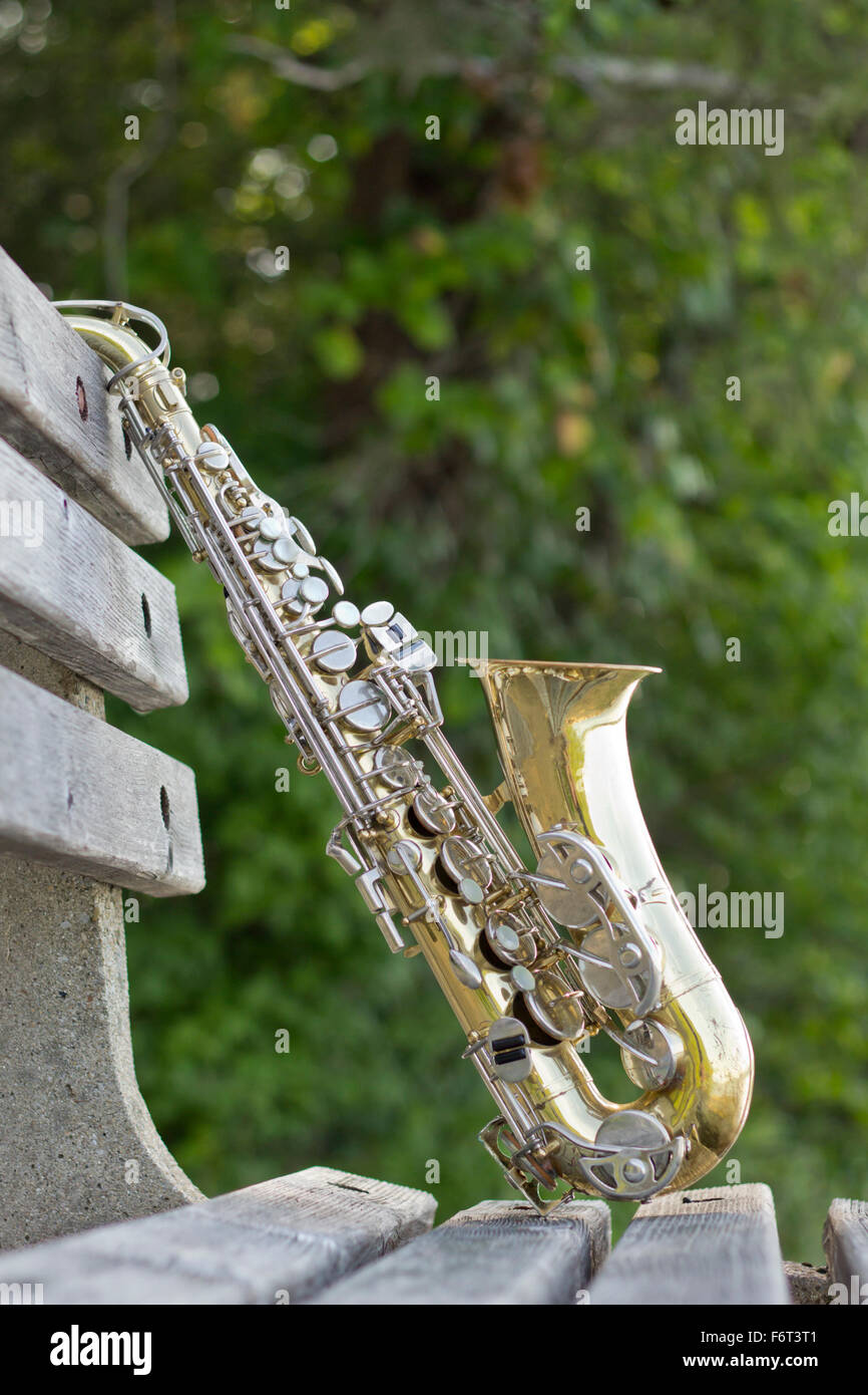 Summer Jazz saxophone in nature propped on park bench Stock Photo - Alamy