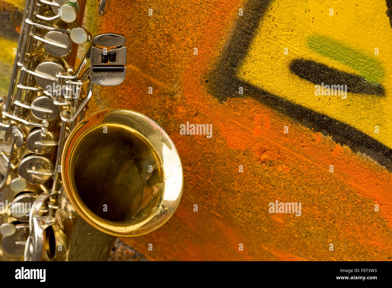 Lone old saxophone leans against brick wall outside abandoned jazz club ...