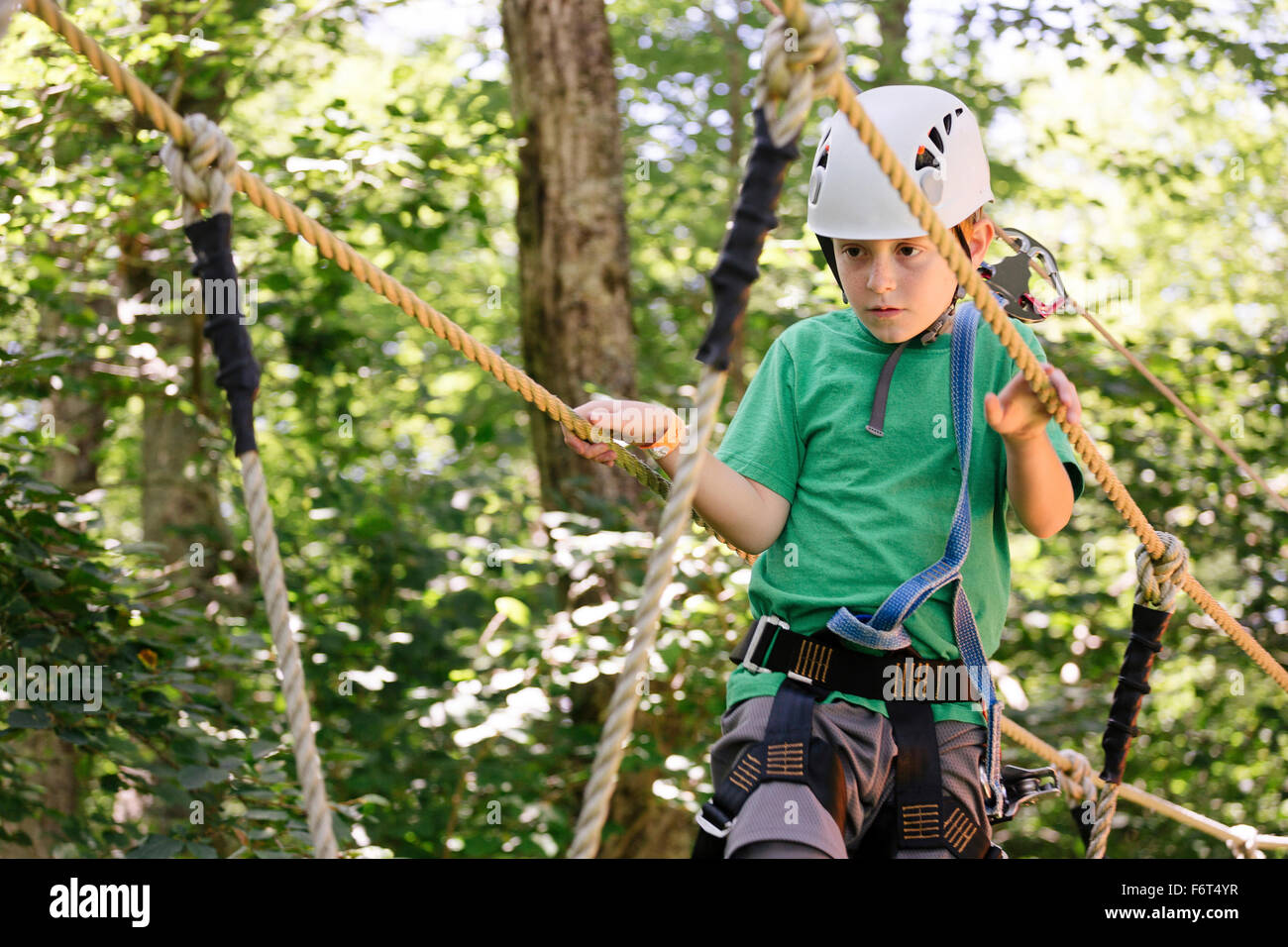 Caucasian boy balancing on rope bridge Stock Photo - Alamy
