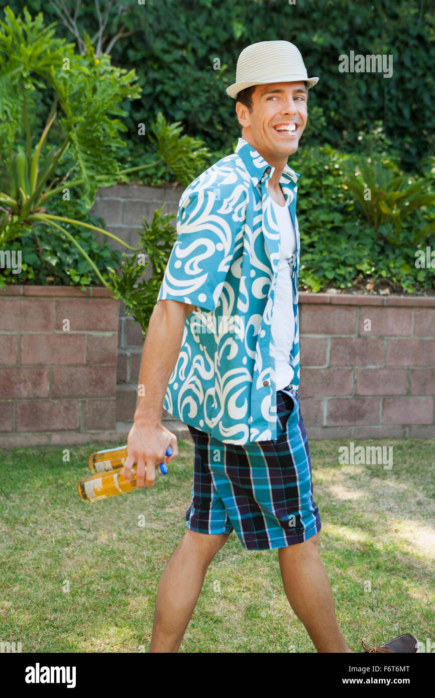 Man carrying cans of beer in backyard Stock Photo - Alamy