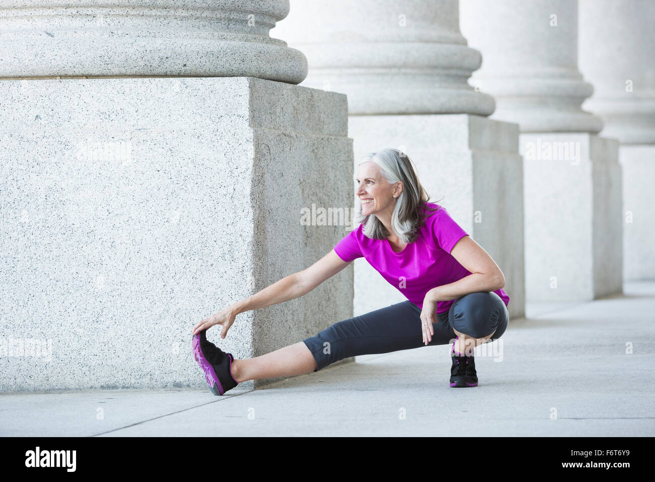 Caucasian woman stretching outside courthouse Stock Photo - Alamy