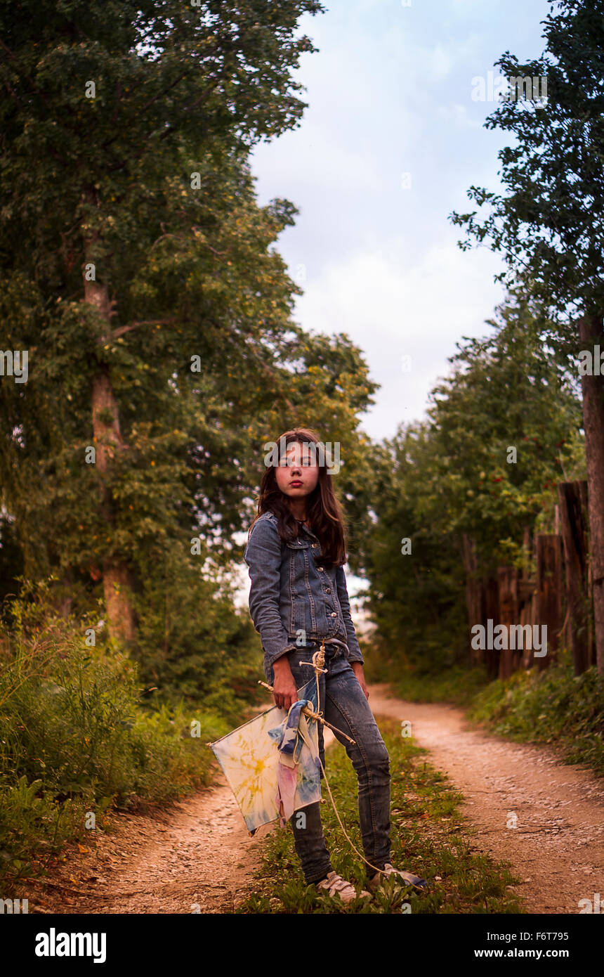 Caucasian teenage girl carrying kite on dirt road Stock Photo - Alamy