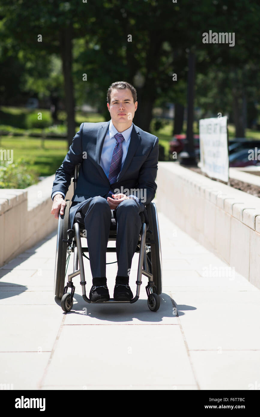 Paraplegic businessman in wheelchair on walkway Stock Photo - Alamy