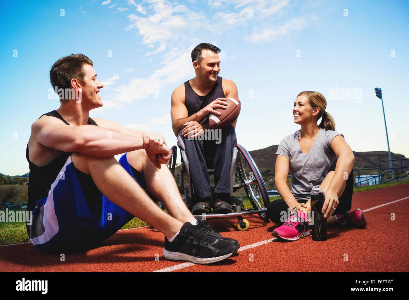 Paraplegic athlete in wheelchair and friends on track Stock Photo - Alamy