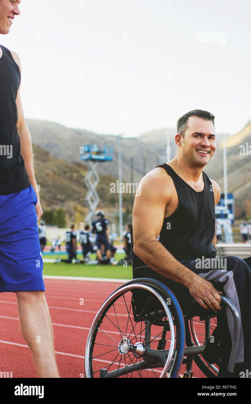 Paraplegic athlete in wheelchair and friend on track Stock Photo - Alamy