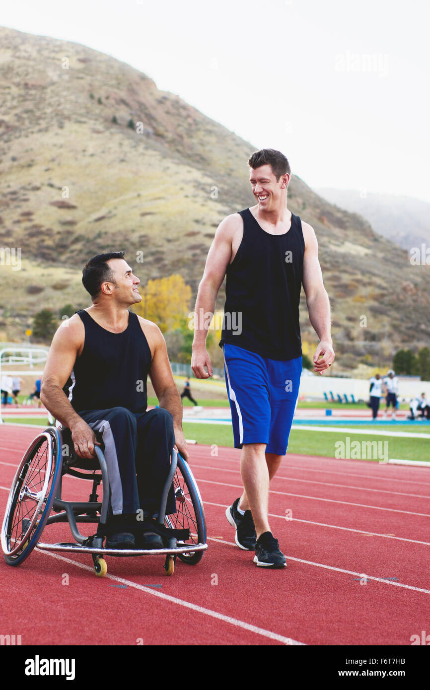 Paraplegic athlete in wheelchair with friend on track Stock Photo - Alamy