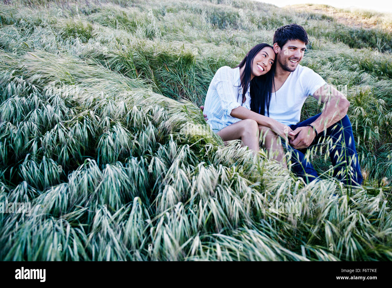 Couple sitting in grass Stock Photo - Alamy