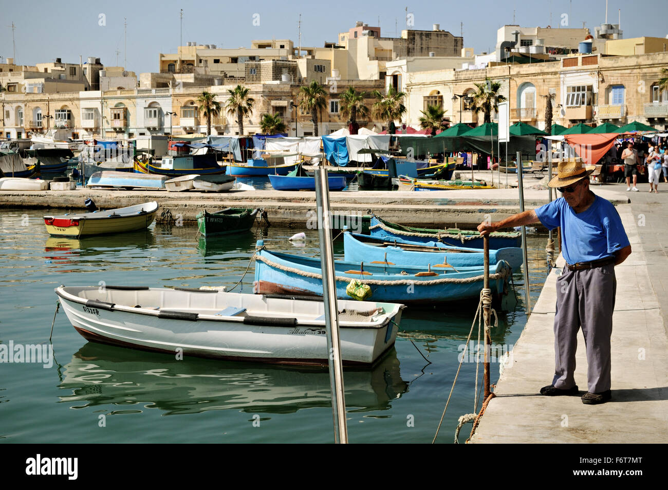 Old man with a hat standing in the harbour of Marsaxlokk, Malta Stock ...