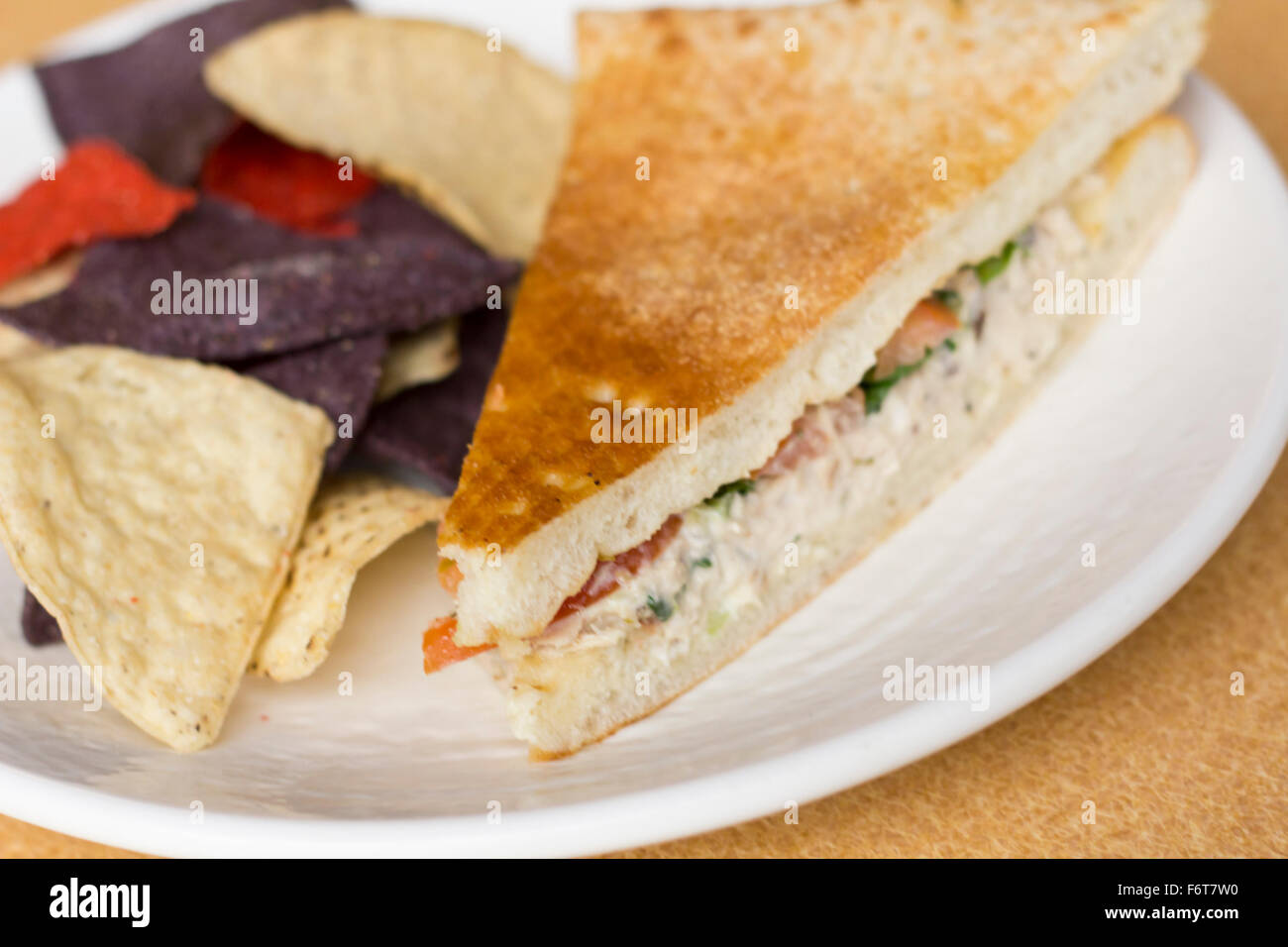 Triangle sliced tuna salad panini with colorful tortilla chips Stock ...