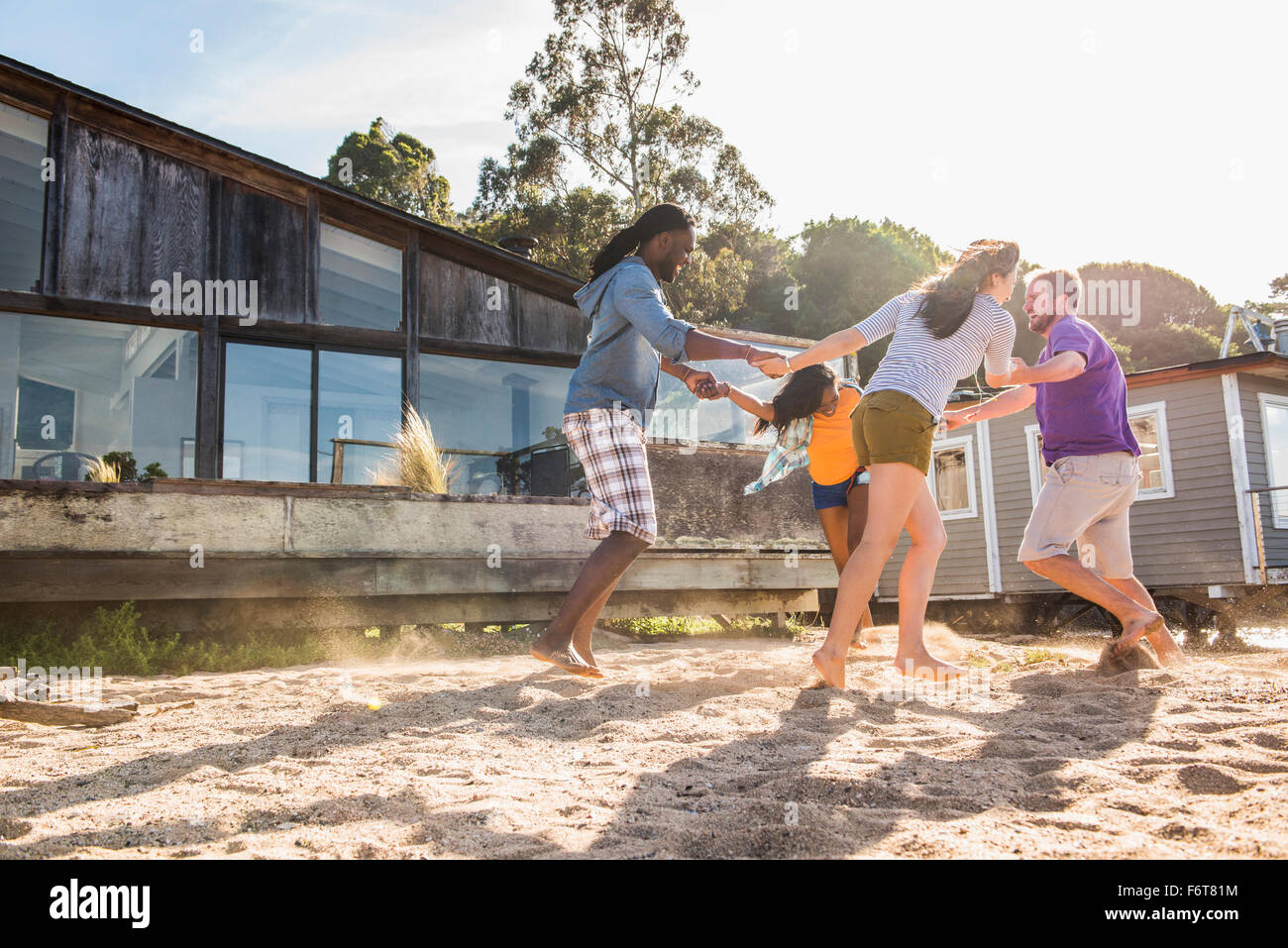 Friends playing in sand Stock Photo - Alamy