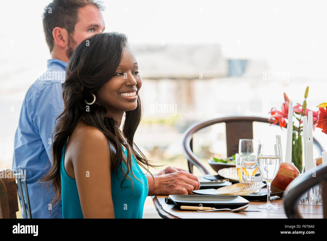 Couple smiling at dining room table Stock Photo - Alamy