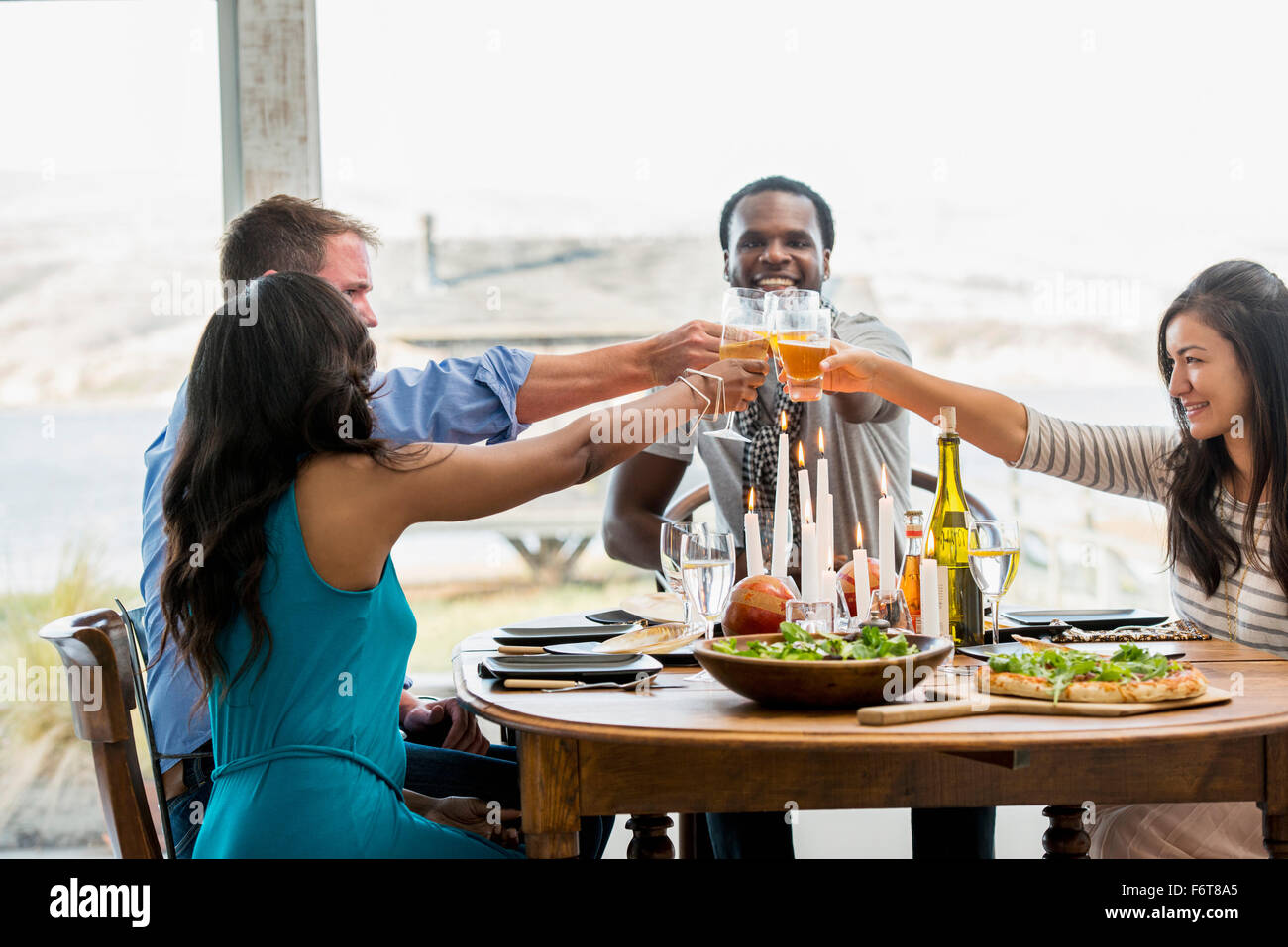 Friends toasting at dining room table Stock Photo - Alamy
