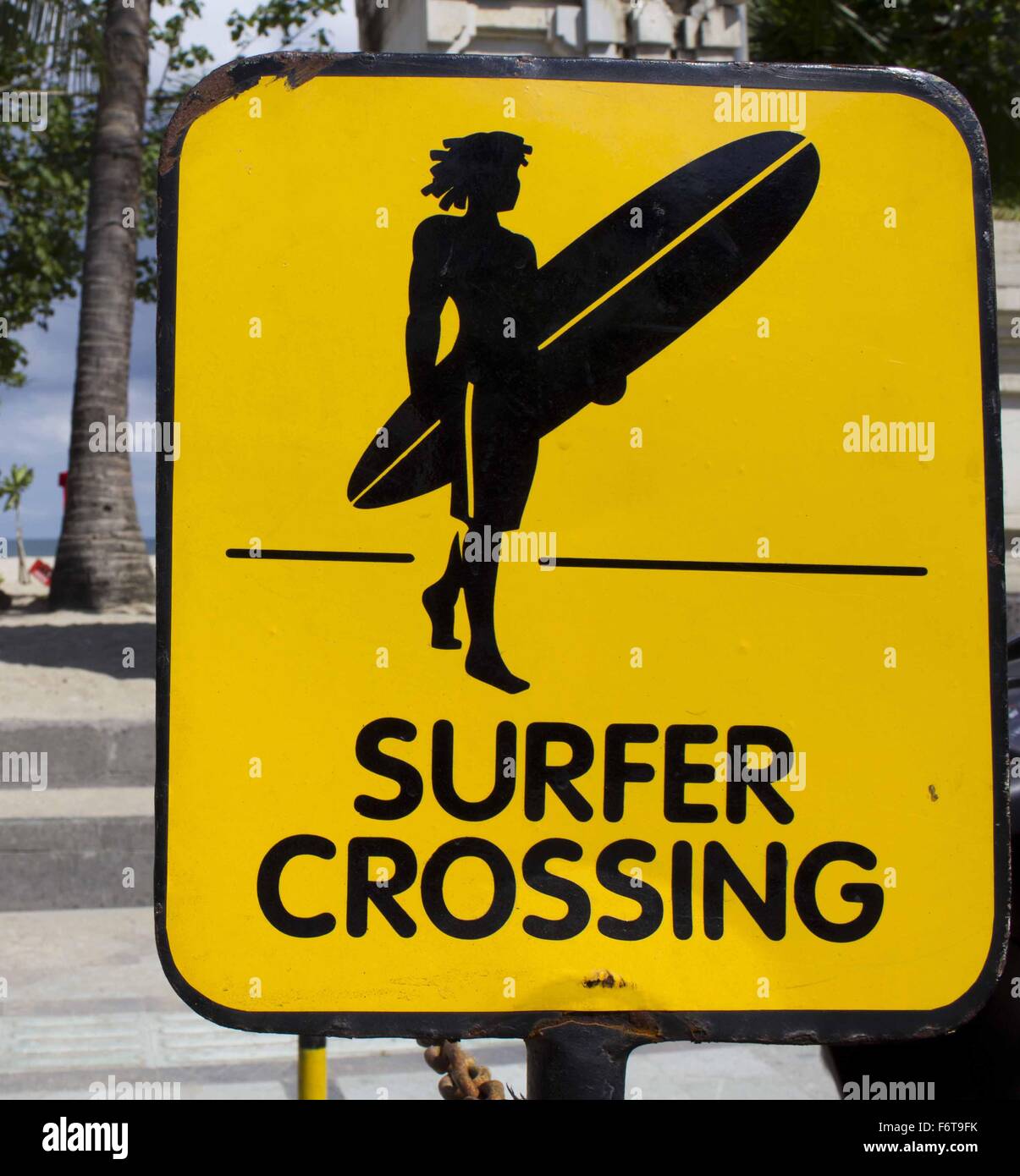 BALI, INDONESIA - JULY 7 2012: Surfer crossing warning sign on Kuta ...