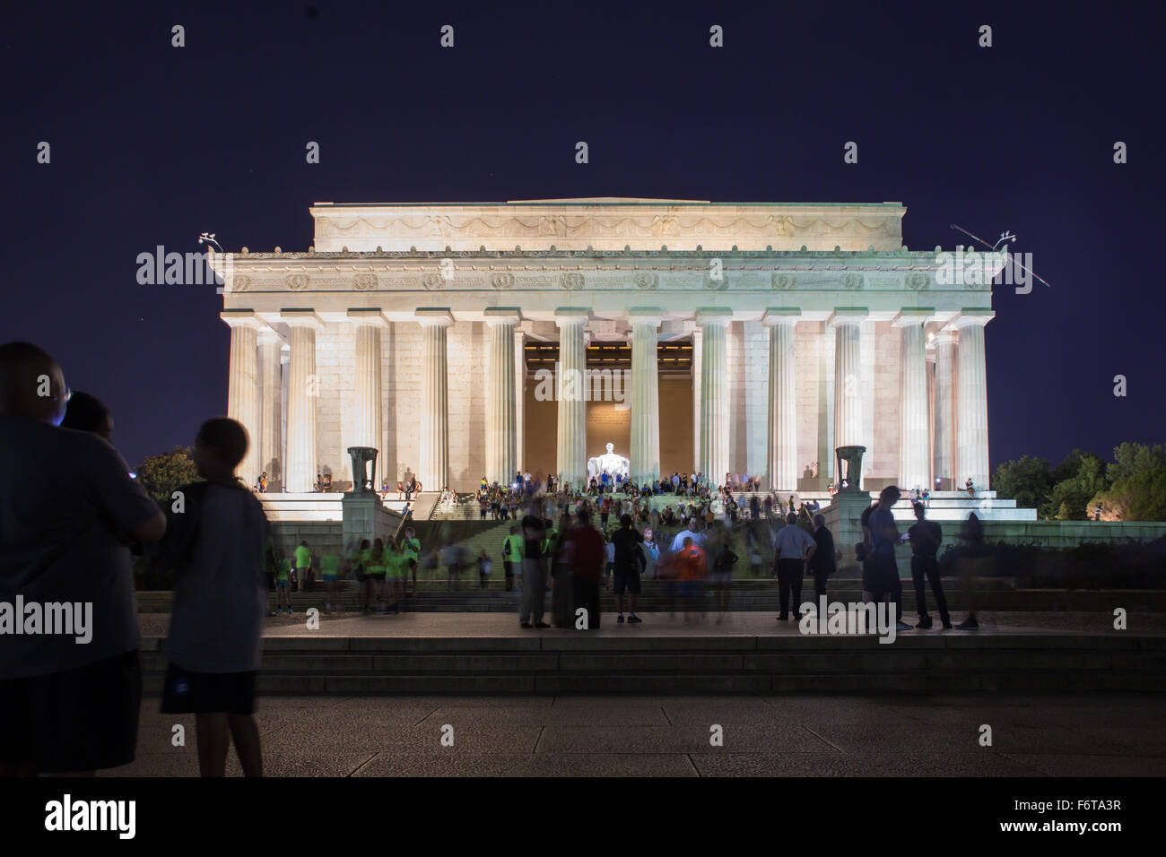 Pictured here is a night view of the Lincoln Memorial with visitors ...