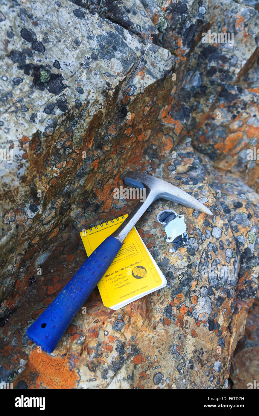 Mineral exploration with rock hammer, notebook, and magnifying glass on ...