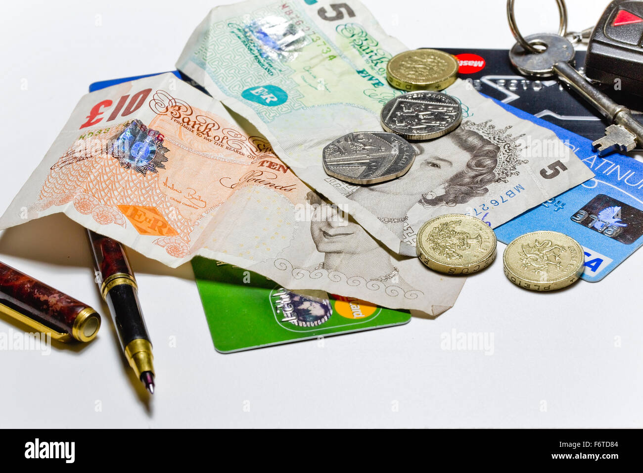 Coins, credit cards and currency notes thrown lazily on a table along ...