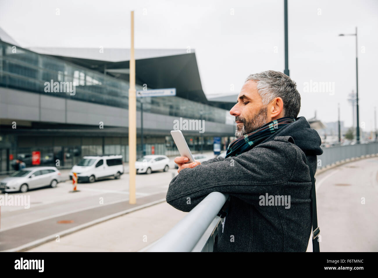 Austria, Vienna, man leaning on a railing near central station looking ...