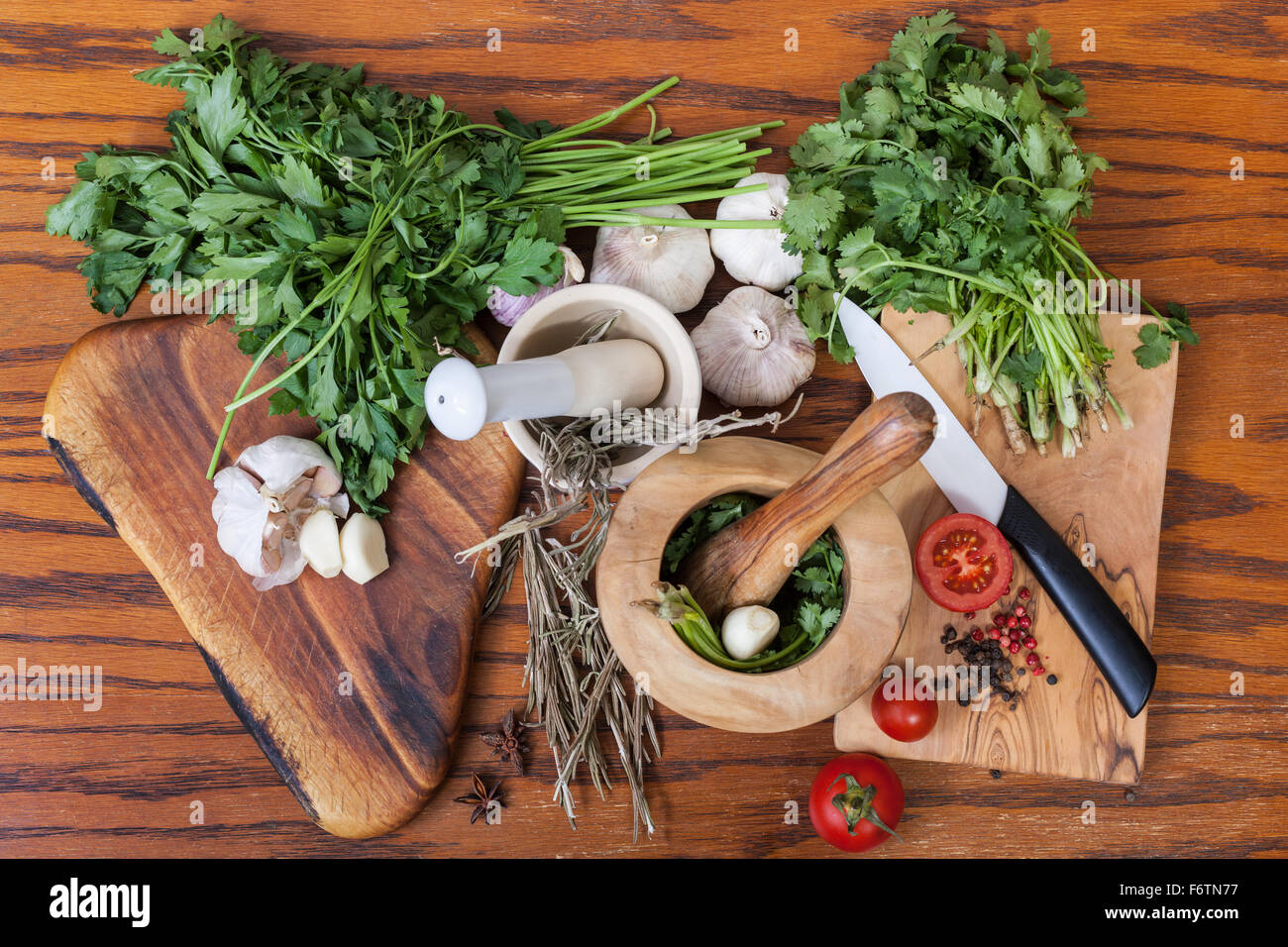 cooking seasonings - above view of mortars and fresh herbs on wooden ...