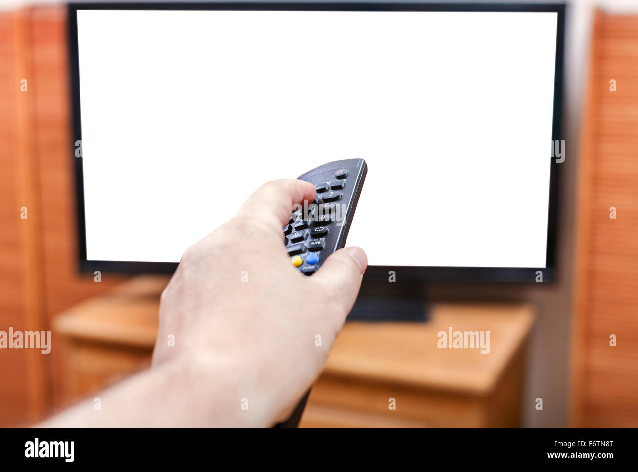 Hand switching channels on the TV with cut out screen by remote control ...